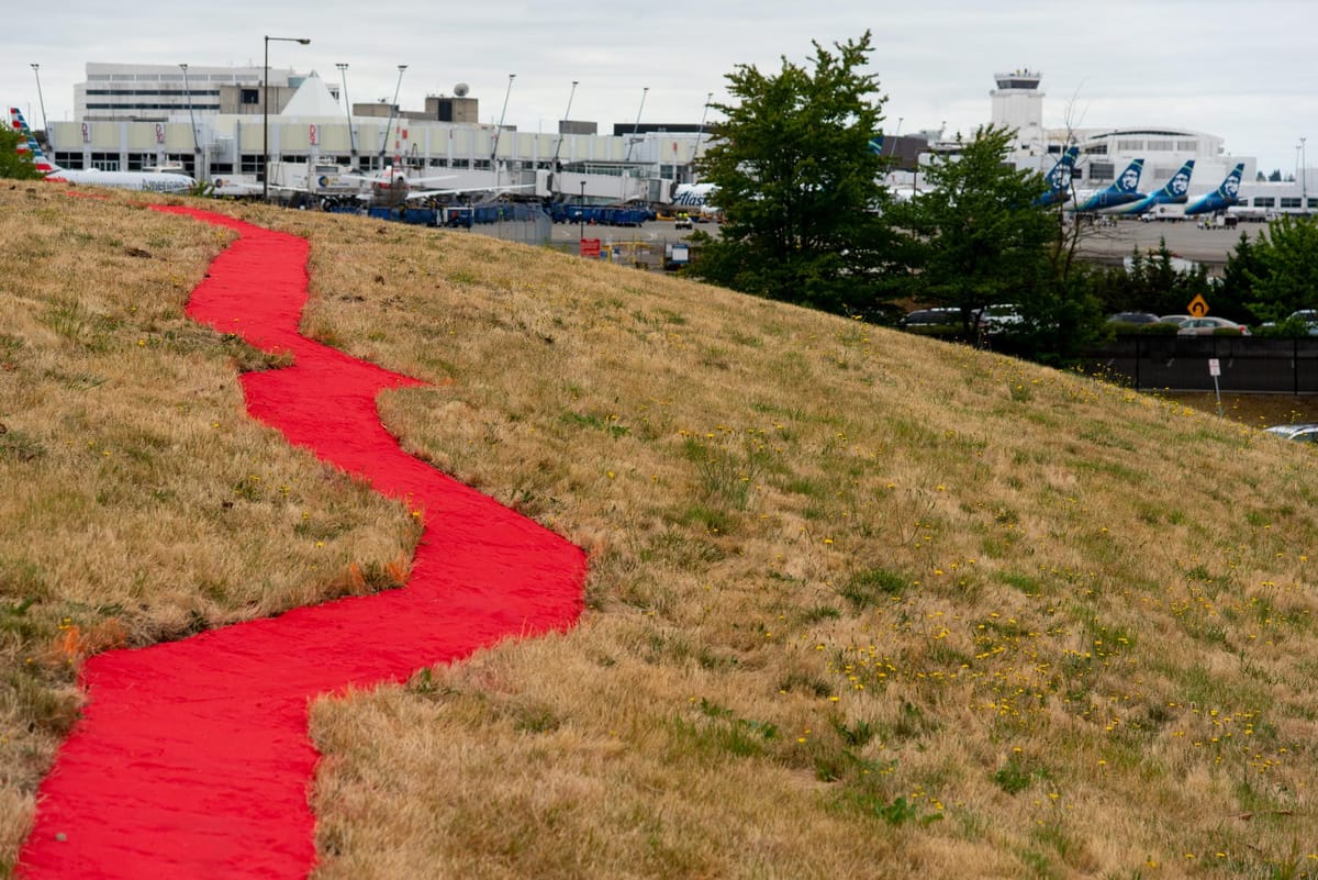 At Sea-Tac airport, a red border made of sand draws attention to human trafficking | Cascade PBS